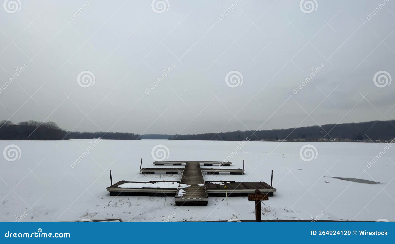 Winter Scene Of The Frozen And Snow Covered Lake With A Dock And A
