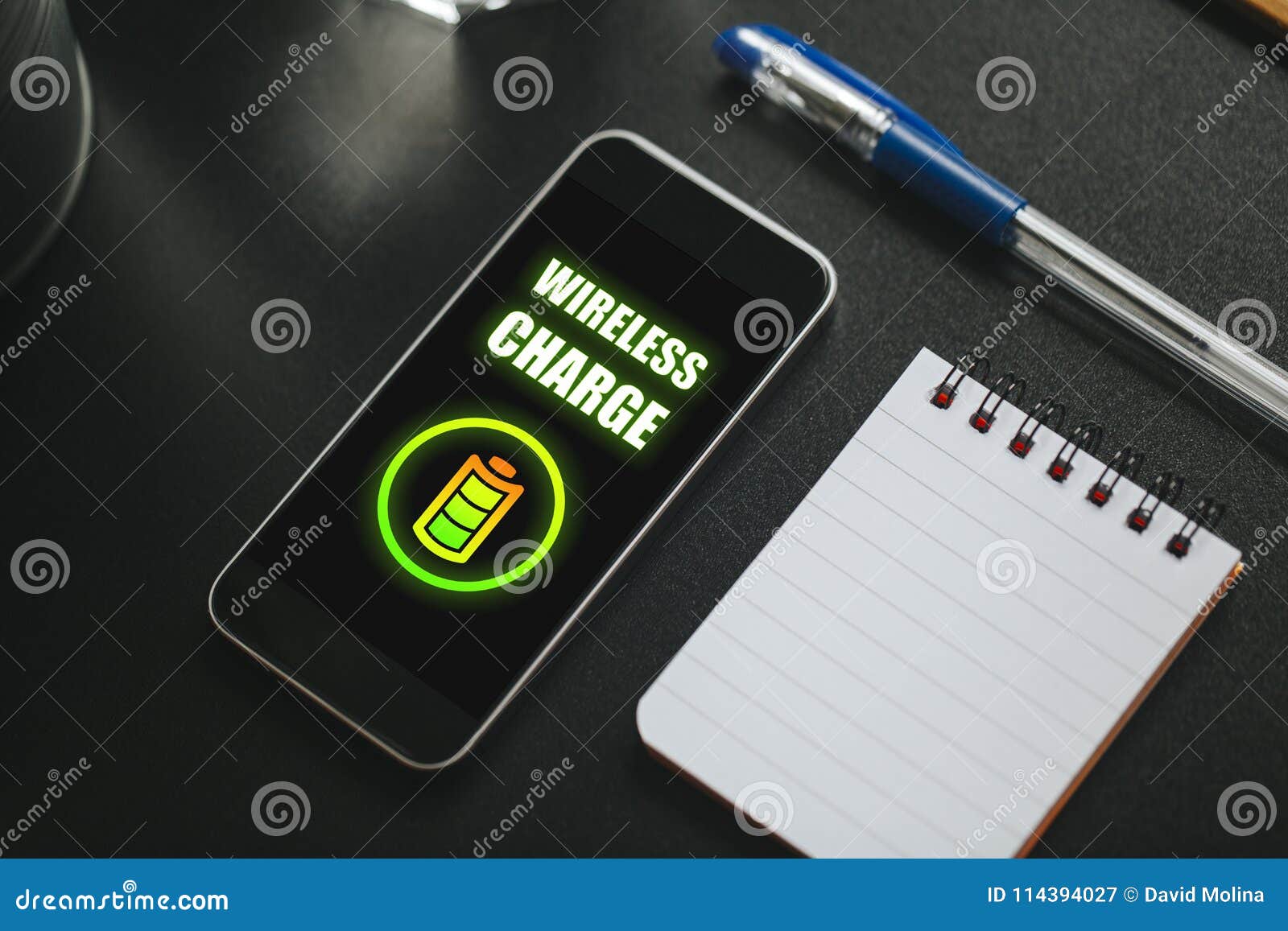Wireless Charge in a Mobile Phone Screen Over a Black Business Table ...
