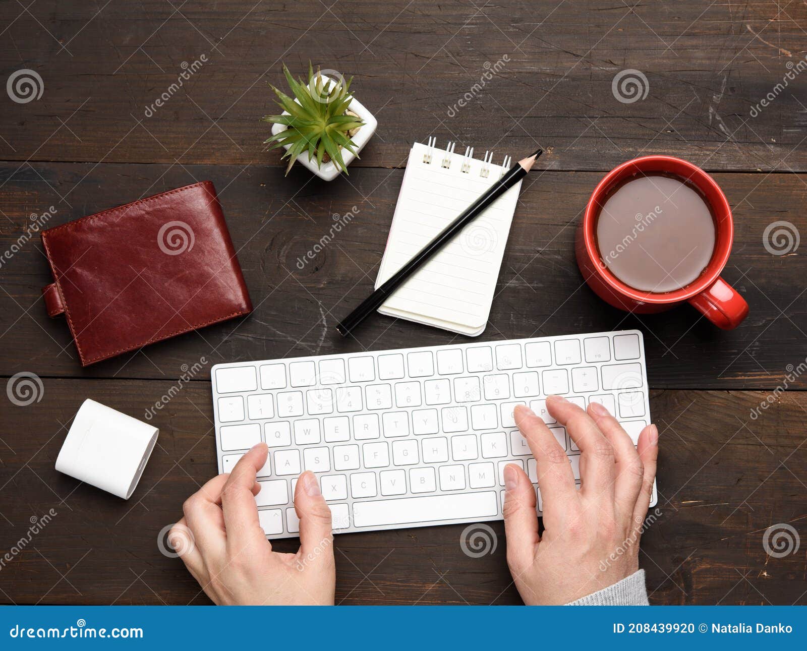 Wireless Keyboard and Two Hands are Typing on a Wooden Table, Next To a ...
