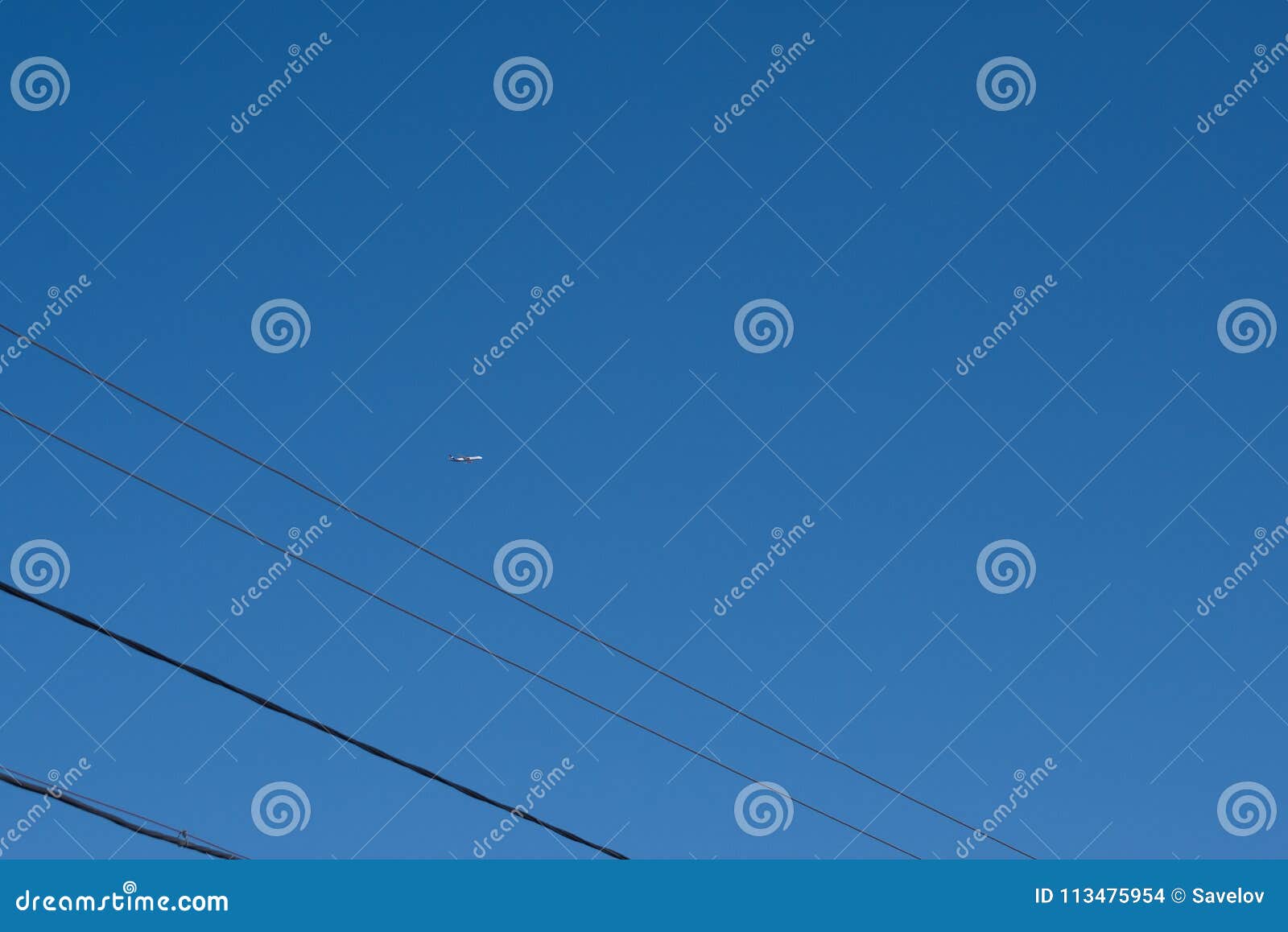 Wires and a Flying Airplane on a Blue Sky Stock Photo - Image of cable ...