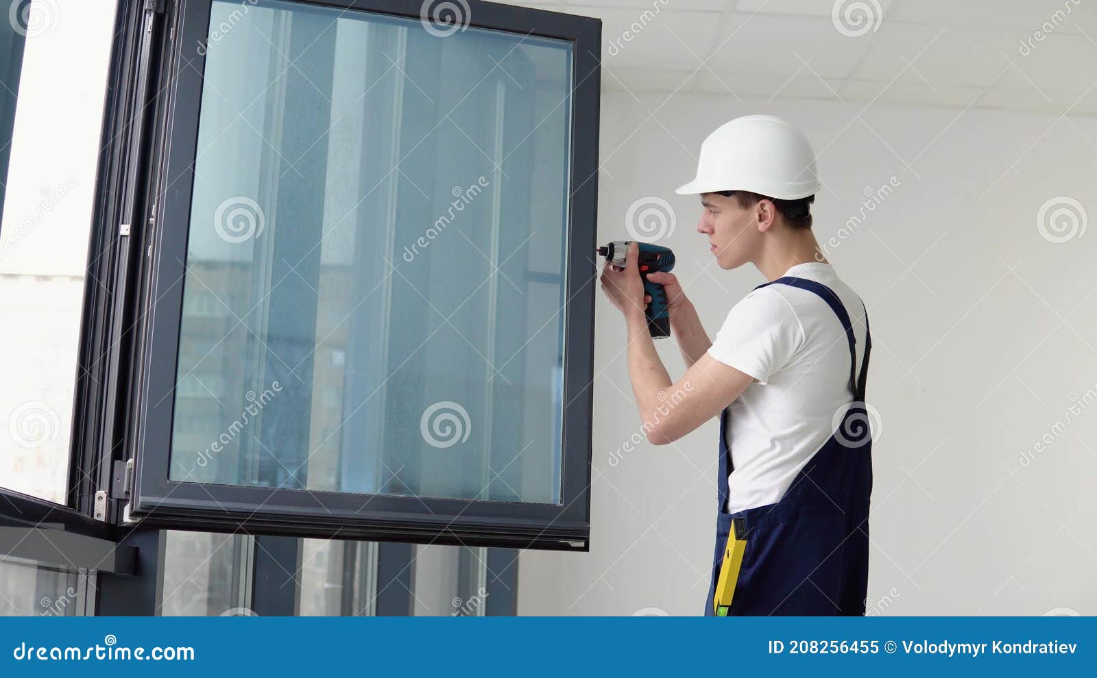 The Wizard Installs the Screws in the Window Frame with a Screwdriver ...