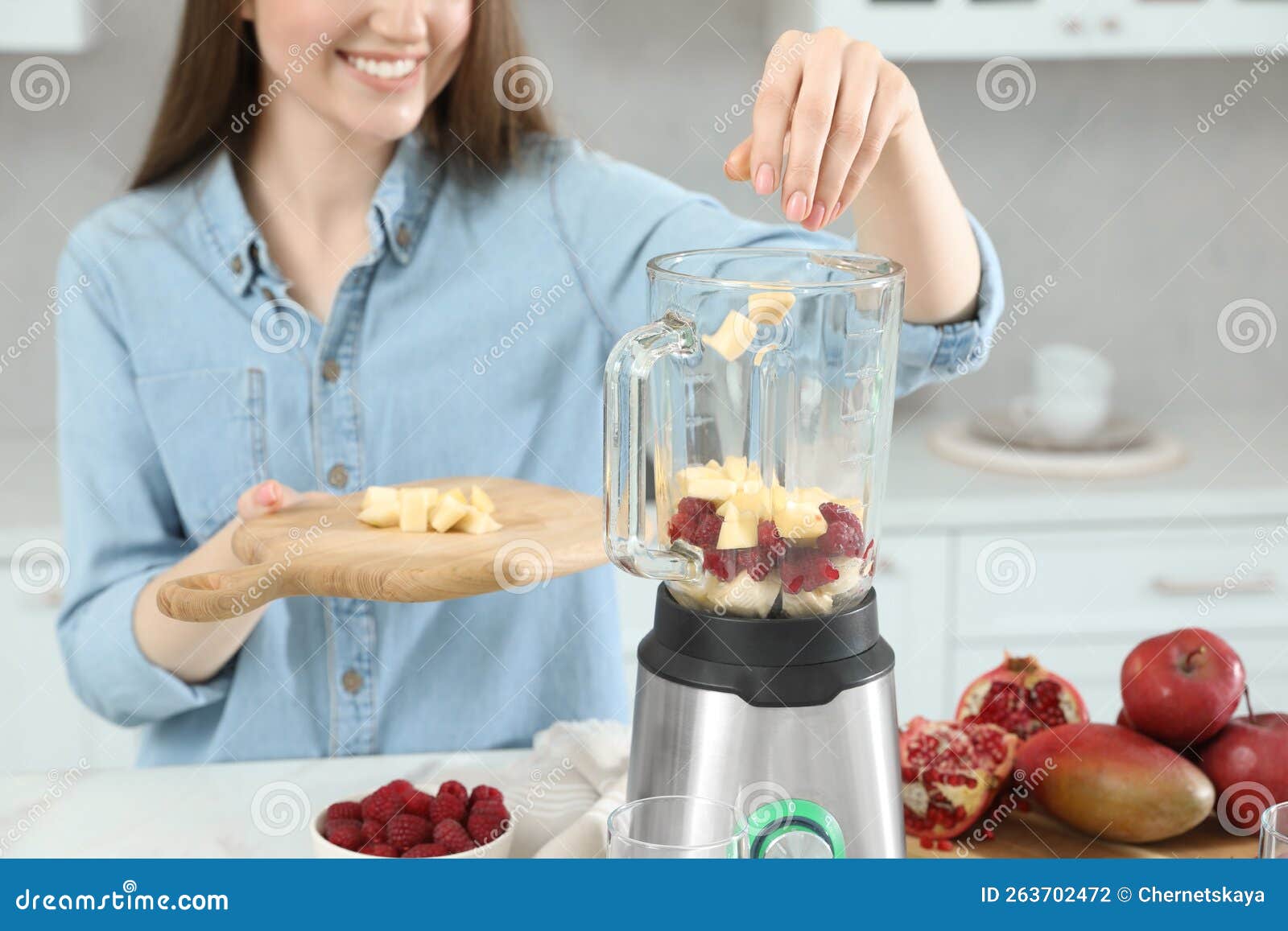 Woman Adding Mango into Blender with Ingredients for Smoothie in ...