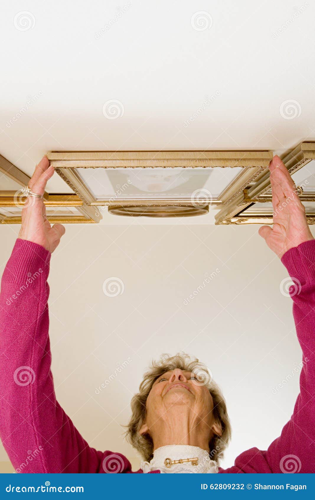 Woman Adjusting Picture Frames Stock Photo - Image of peoples, clean ...