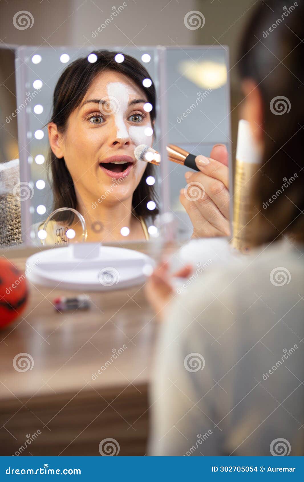 Woman Applying Face Paint Looking at Reflection with Surprise Stock ...