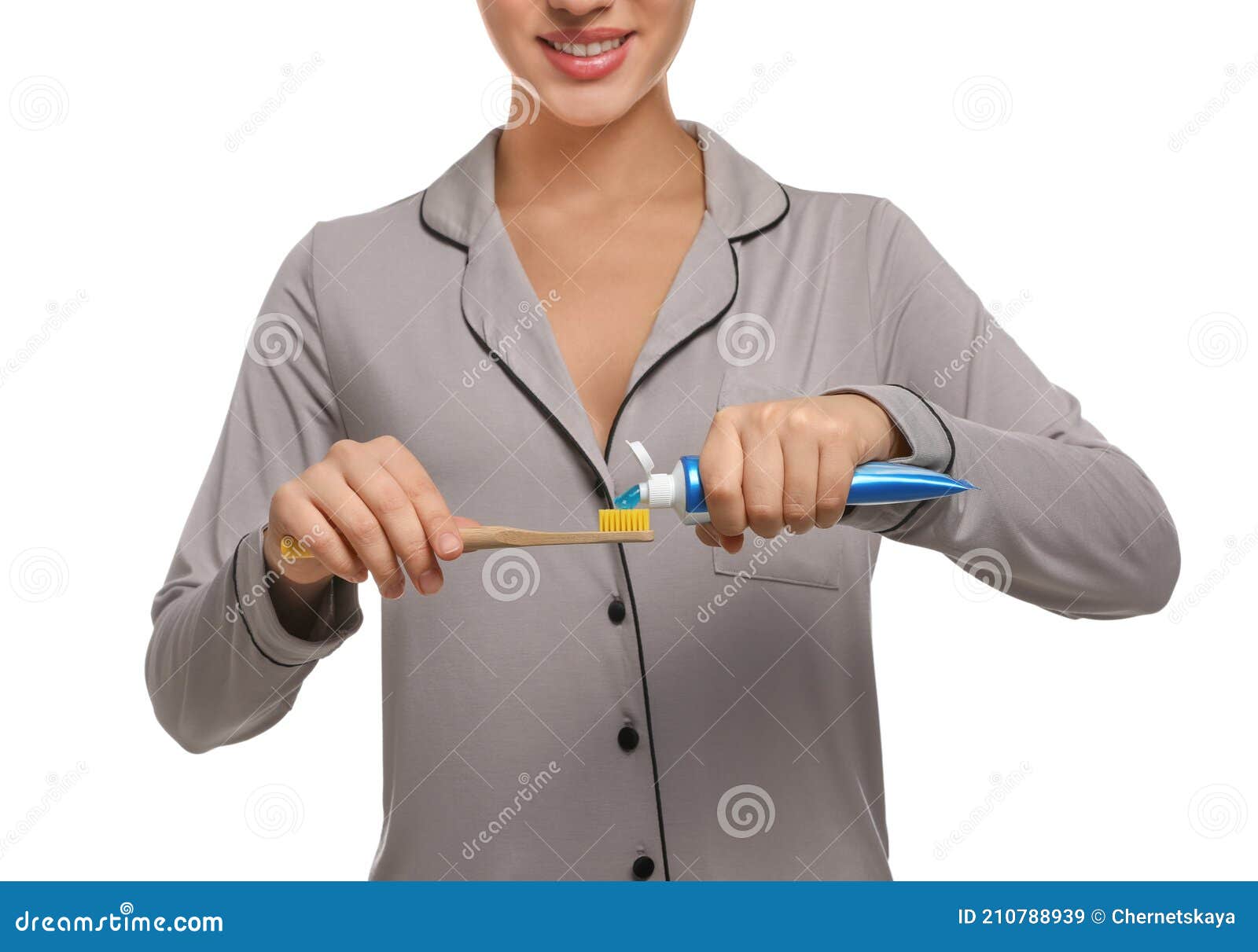 Woman Applying Toothpaste On Brush Against White Background Closeup