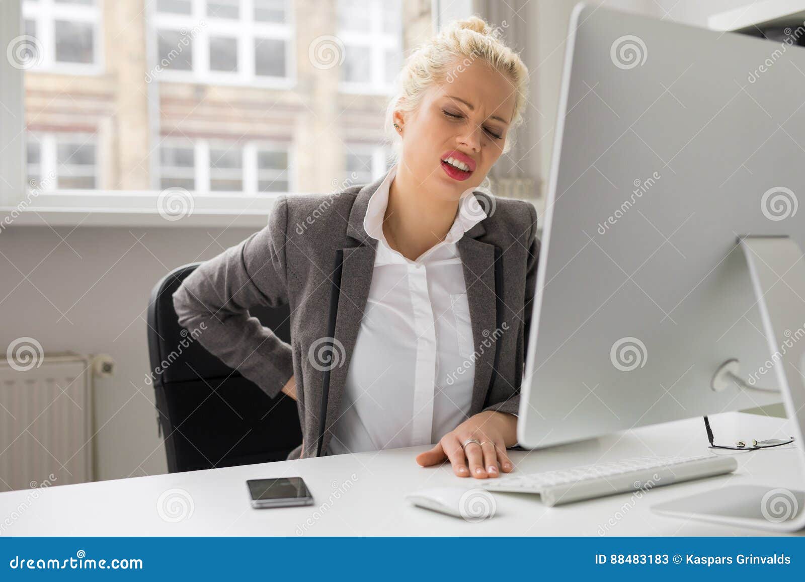 Woman with Back Pain Sitting by the Computer at the Office Stock Image ...