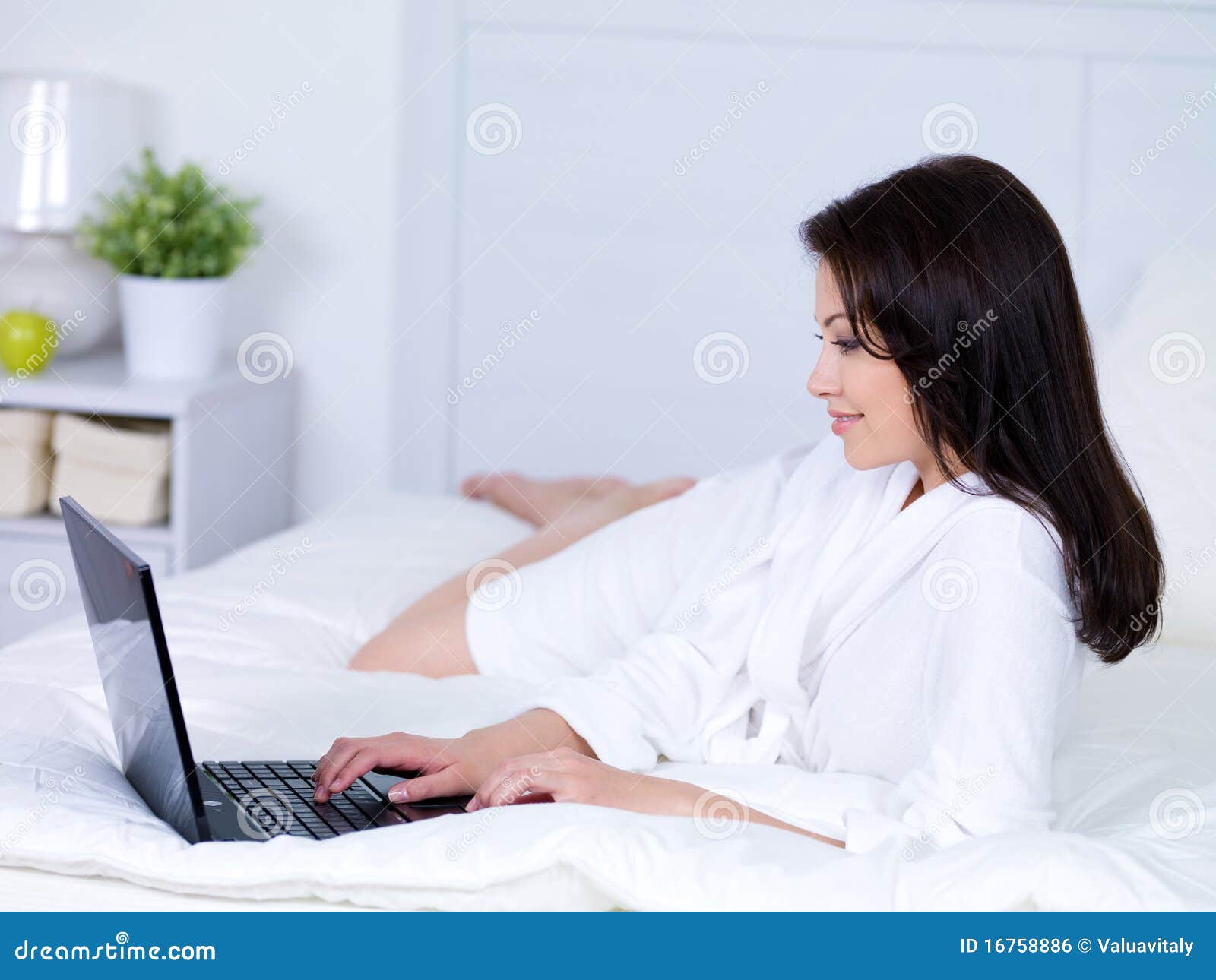Woman on a bed with laptop stock photo. Image of adult - 16758886