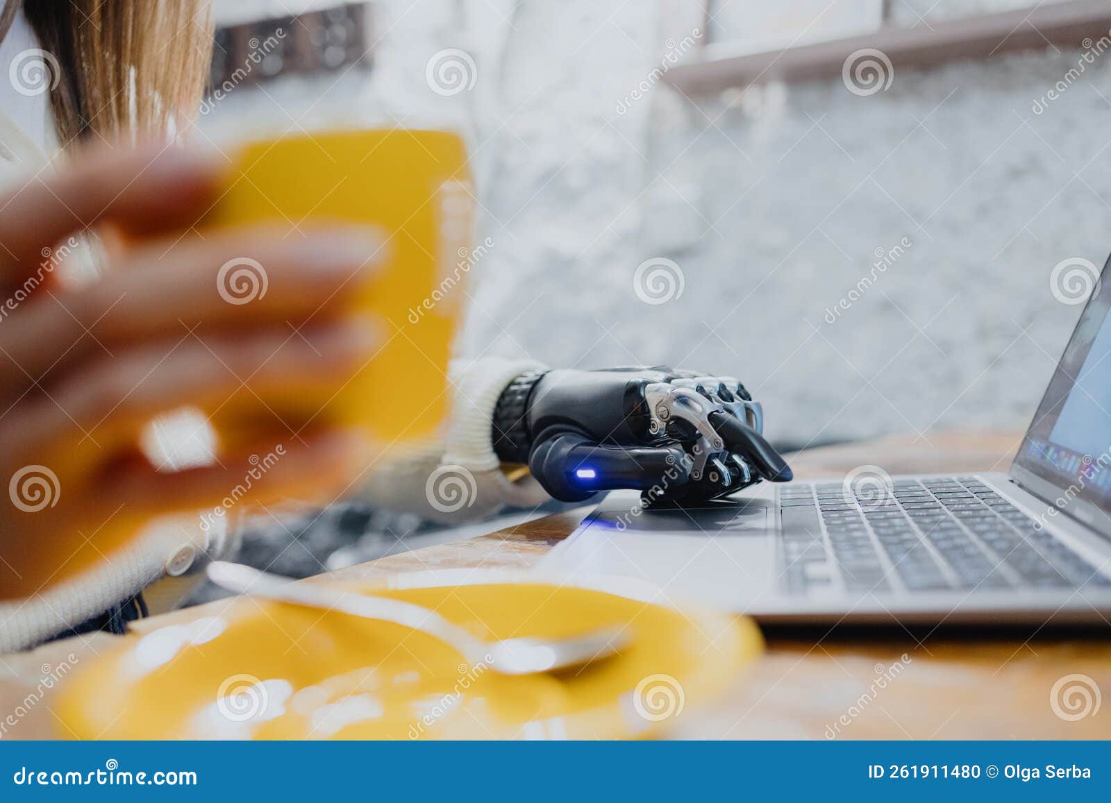 Woman with Bionic Hands is Working on a Laptop and Drinking Coffee in a ...