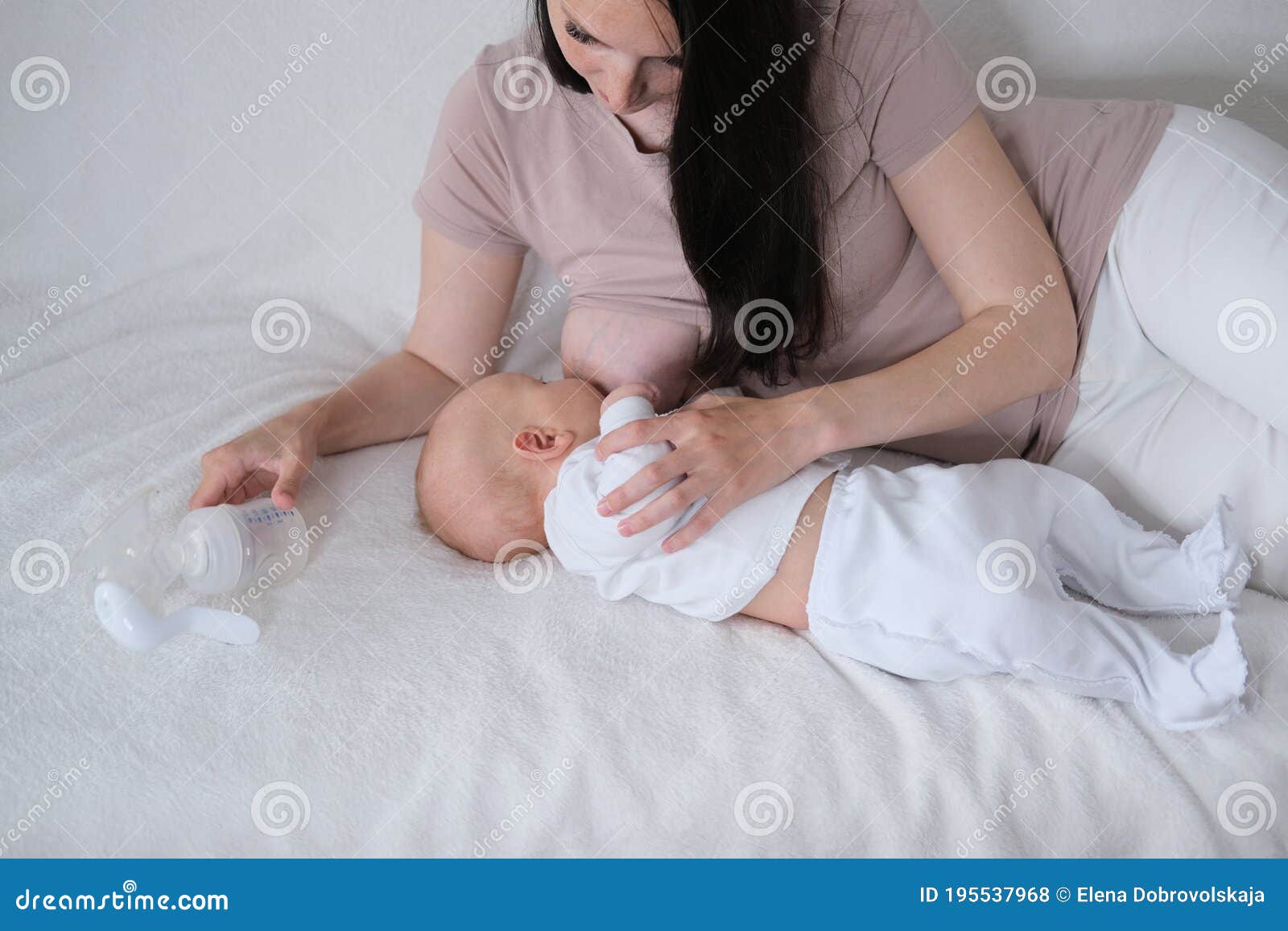 A Woman Is Breastfeeding Her Newborn Son Mother Pumps Milk Into