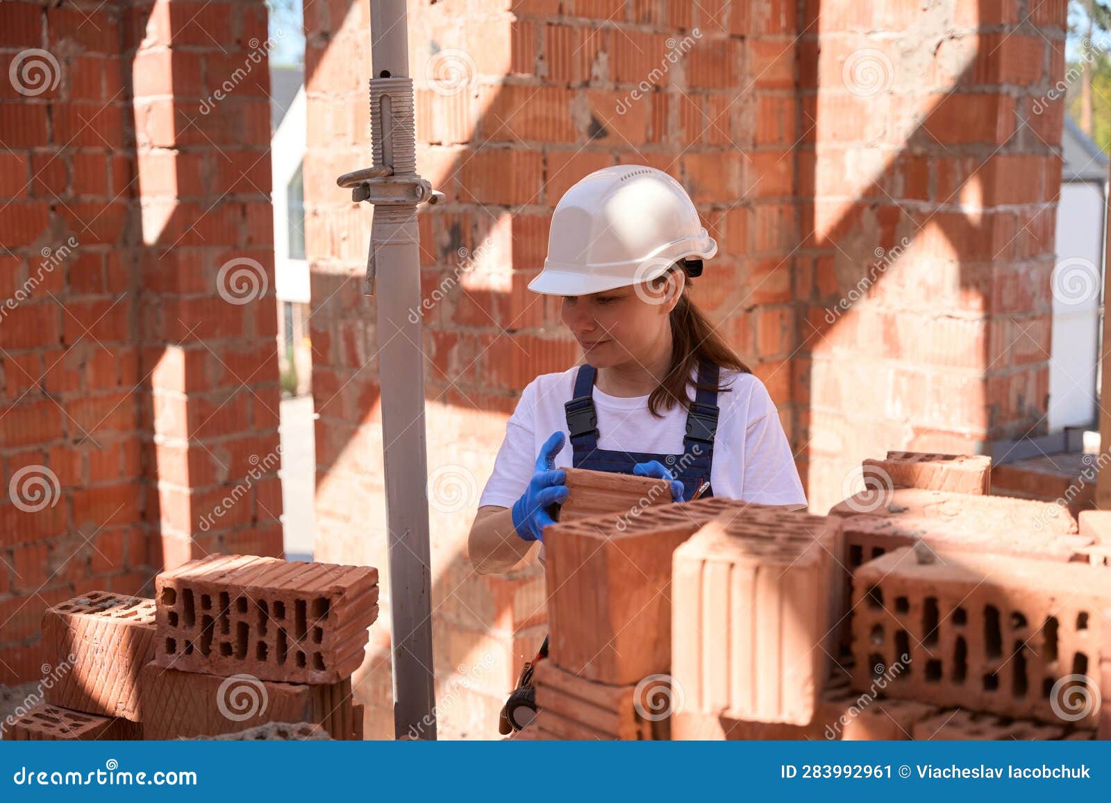 Woman Bricklayer in Hardhat and Building Uniform Sorting Bricks Stock ...