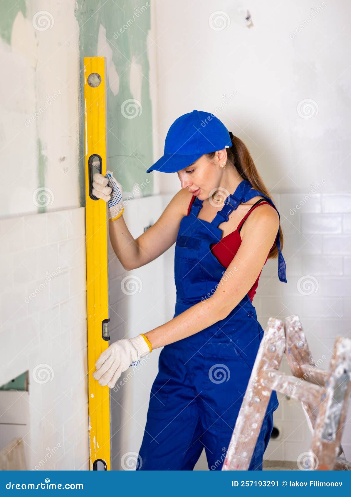Woman Builder in Blue Overalls Measures Deviations from a Given ...