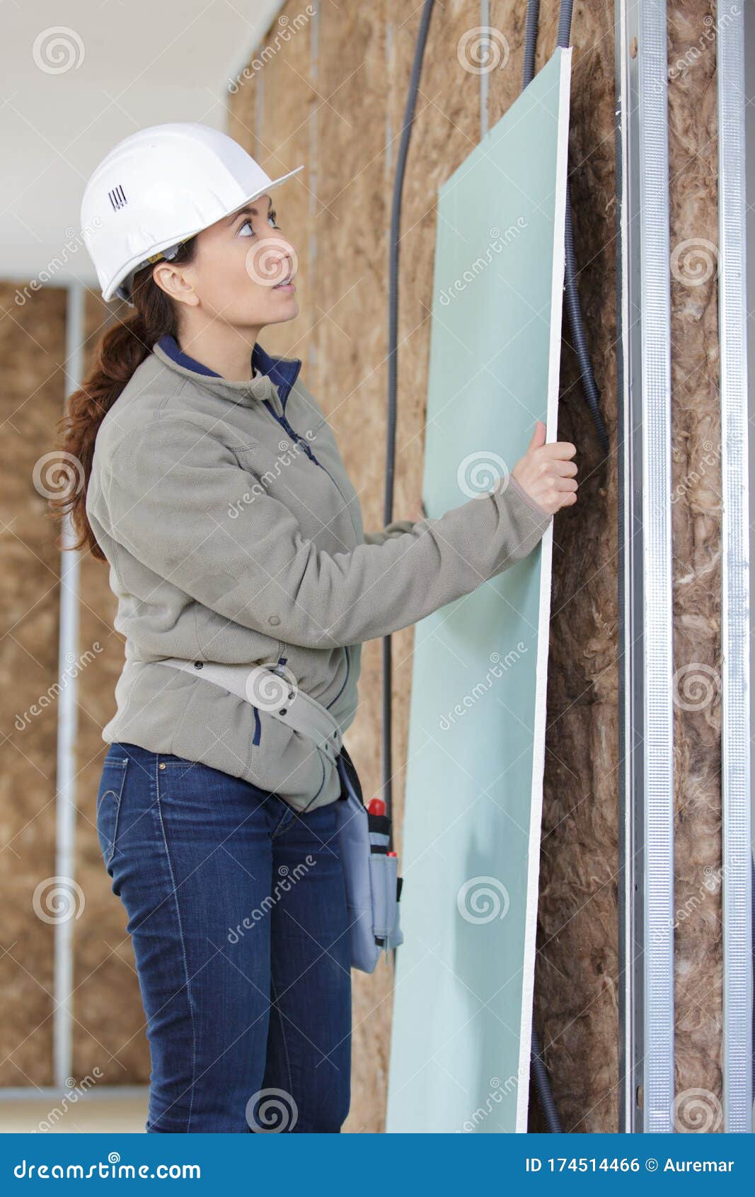 Woman builder fixing wall stock photo. Image of labor - 174514466