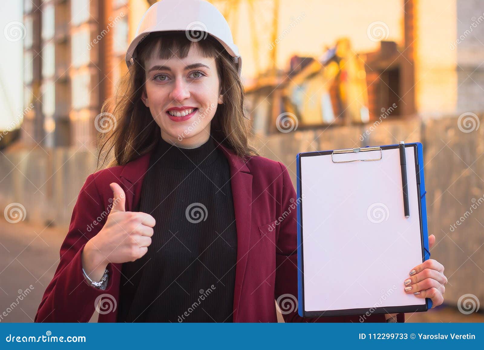 Woman Builder Holding Blueprints, Clipboard. Smiling Architect Girl in ... Woman Builder Holding Blueprints, Clipboard. Smiling Architect Girl in ...