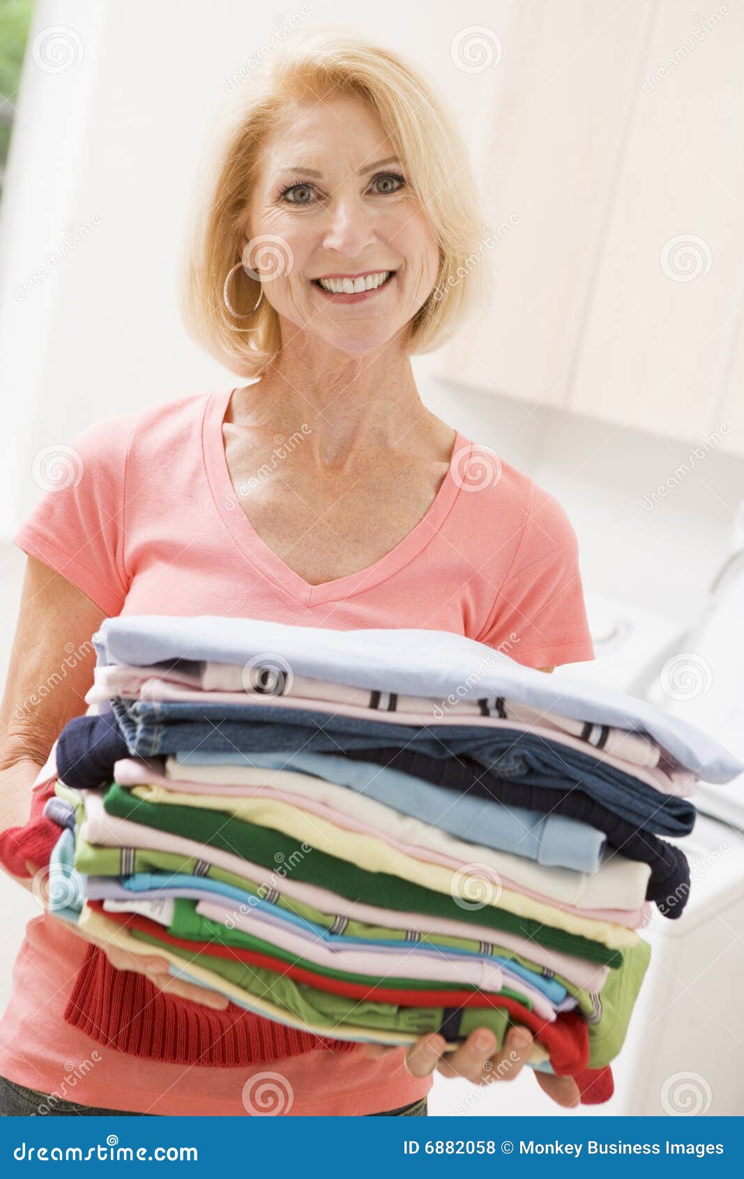 Woman Carrying Folded Up Laundry Stock Photo - Image of smiling, colour ...