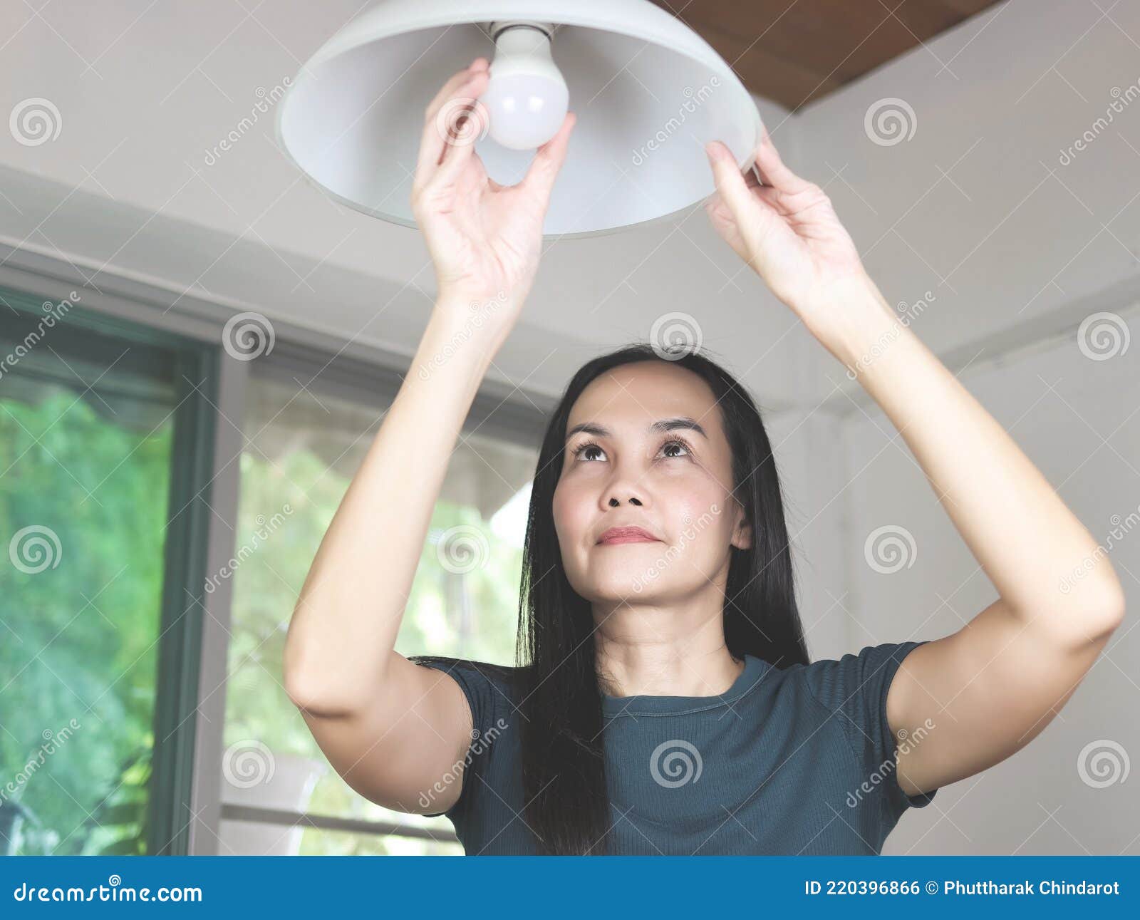 Woman Changing Light Bulb in Her House Stock Photo - Image of energy ...