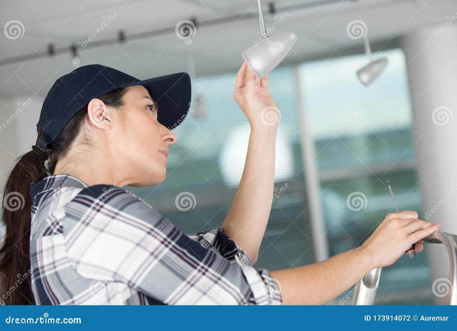 Woman changing lightbulb stock photo. Image of electricity - 173914072