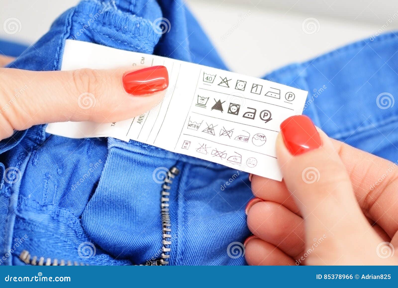 Woman Checking the Care Label of a Pair of Jeans Stock Photo - Image of ...