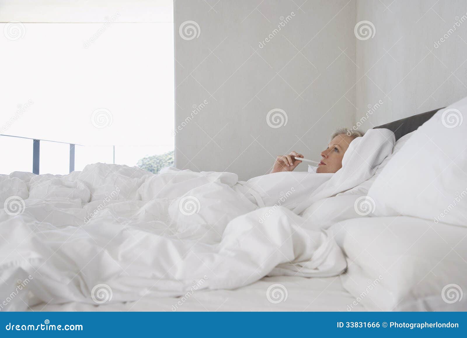 Woman Checking Her Body Temperature in Bed Stock Photo - Image of ...