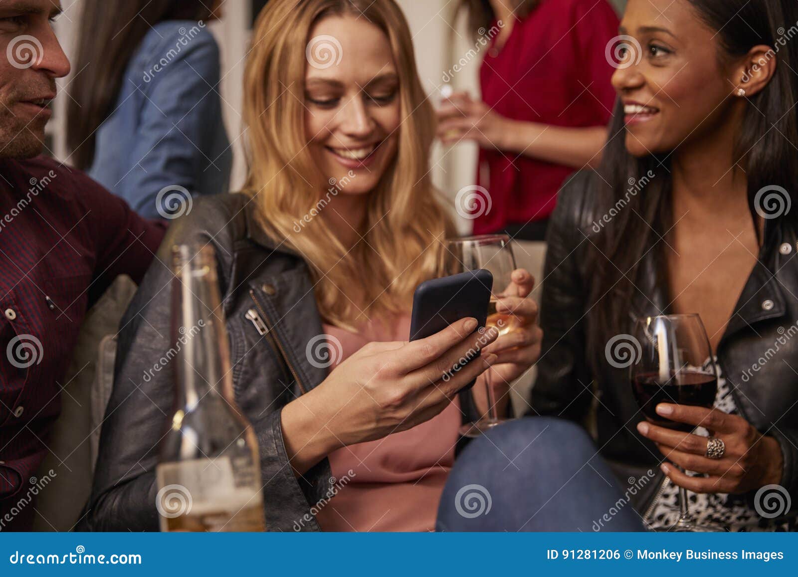 Woman Checking Mobile Phone at Party with Friends Stock Photo - Image ...