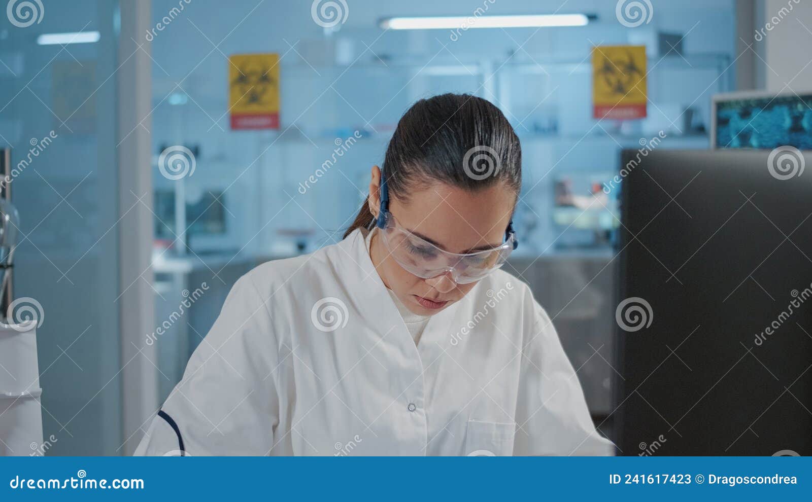 Woman Chemist Taking Notes and Using Computer for Experiment Stock ...
