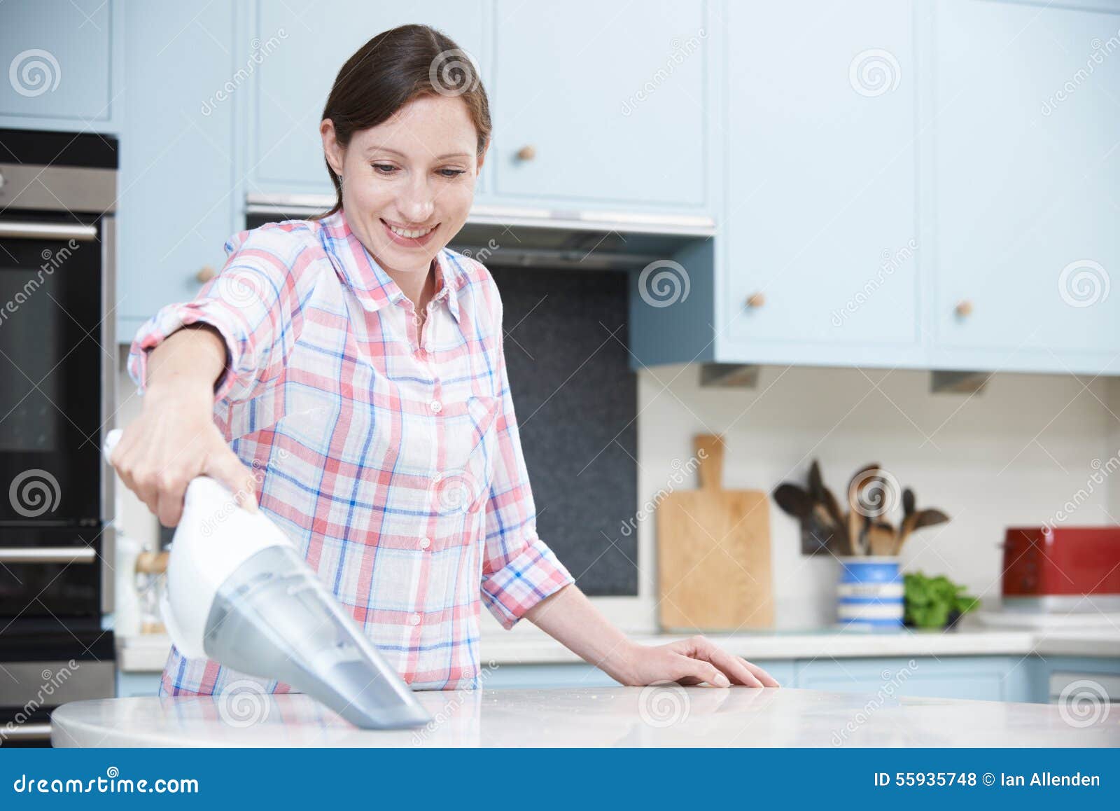 Woman Cleaning Kitchen Using Hand Held Vacuum Cleaner Stock Photo ...