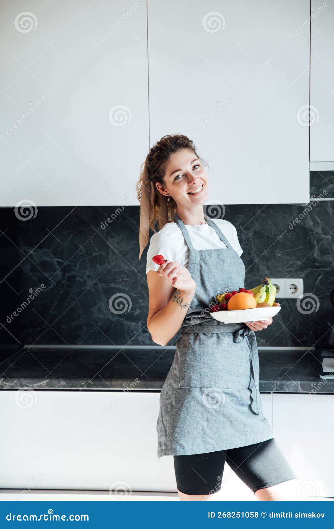 A Woman Cook Stands in the Kitchen with a Plate of Fruit Stock Photo ...