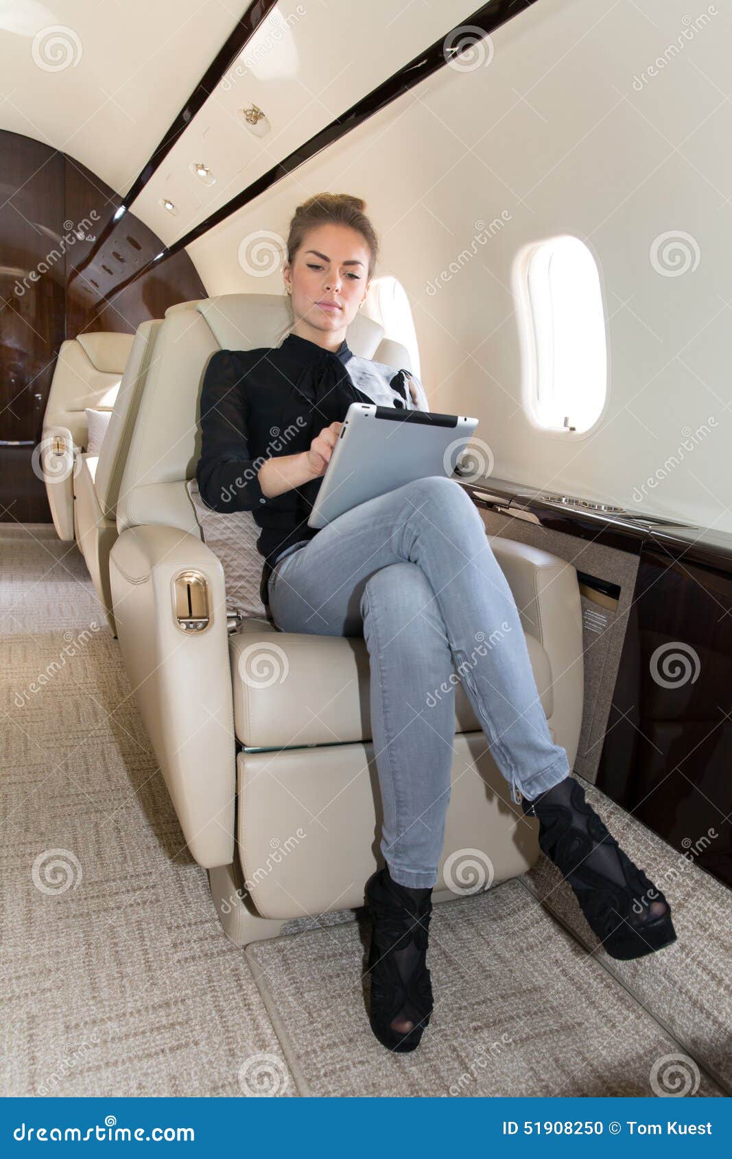 Woman in Corporate Jet Looking at Tablet Computer Stock Photo - Image ...