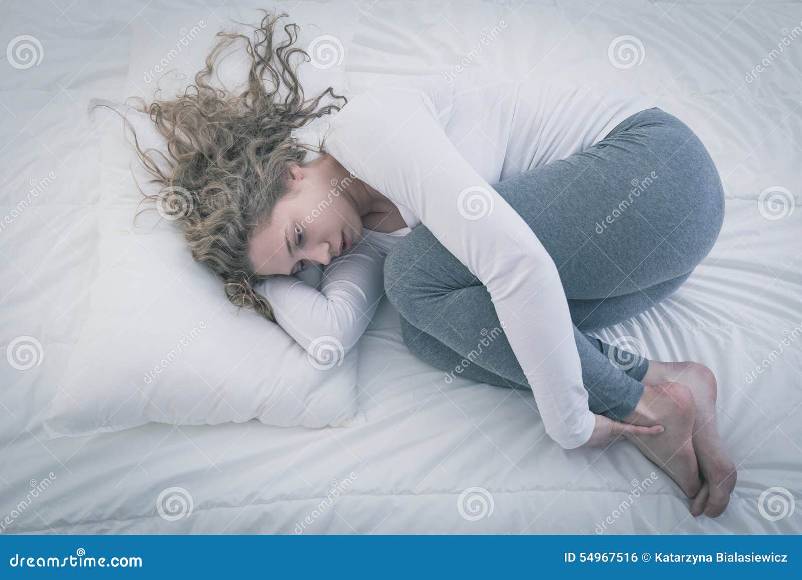 Woman curled up in bed stock photo. Image of teenager - 54967516 Woman curled up in bed stock photo. Image of teenager - 54967516