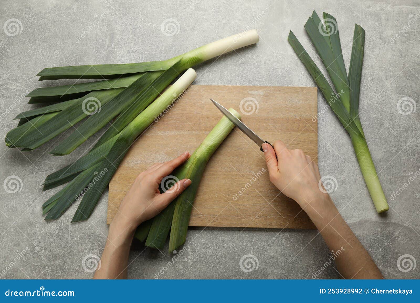Woman Cutting Fresh Raw Leek at Grey Table, Top View Stock Photo ...