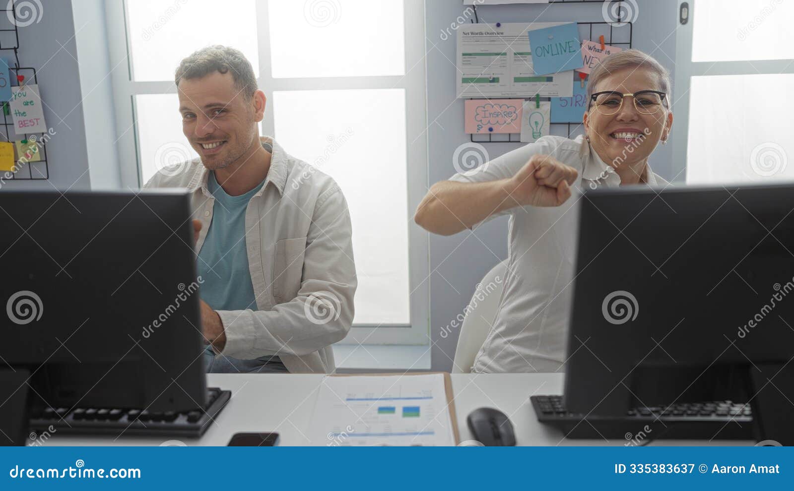 Woman Dancing and Man Smiling in an Office with Computers, Charts, and ...