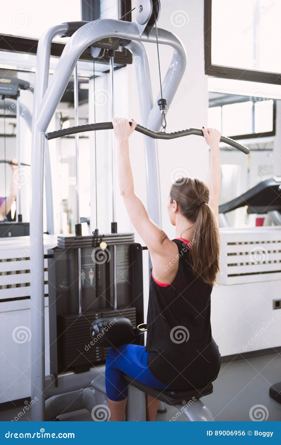 Woman Doing Exercises on a Machine at the Gym Stock Photo - Image of ...