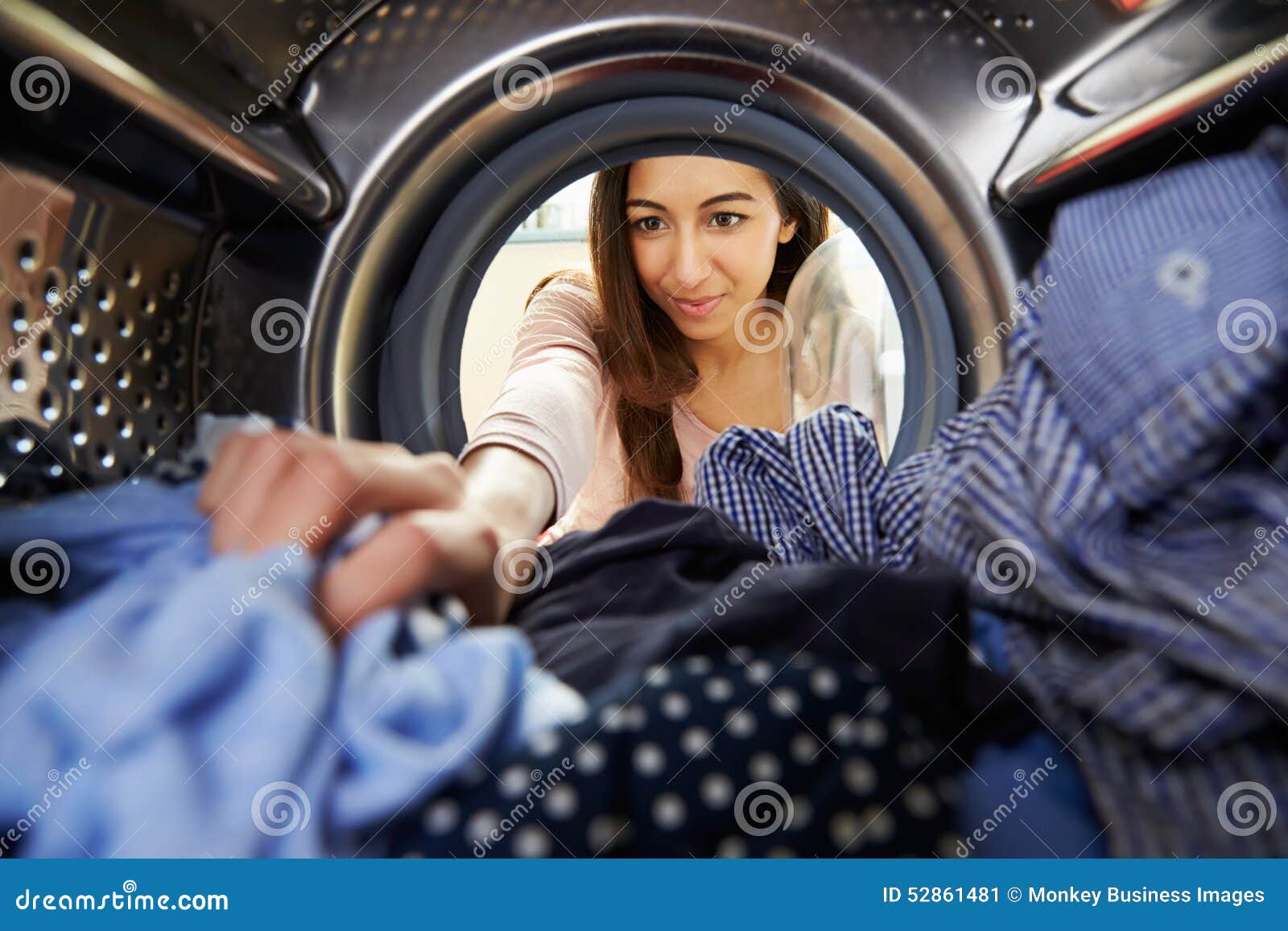 Woman Doing Laundry Reaching Inside Washing Machine Stock Image - Image ...
