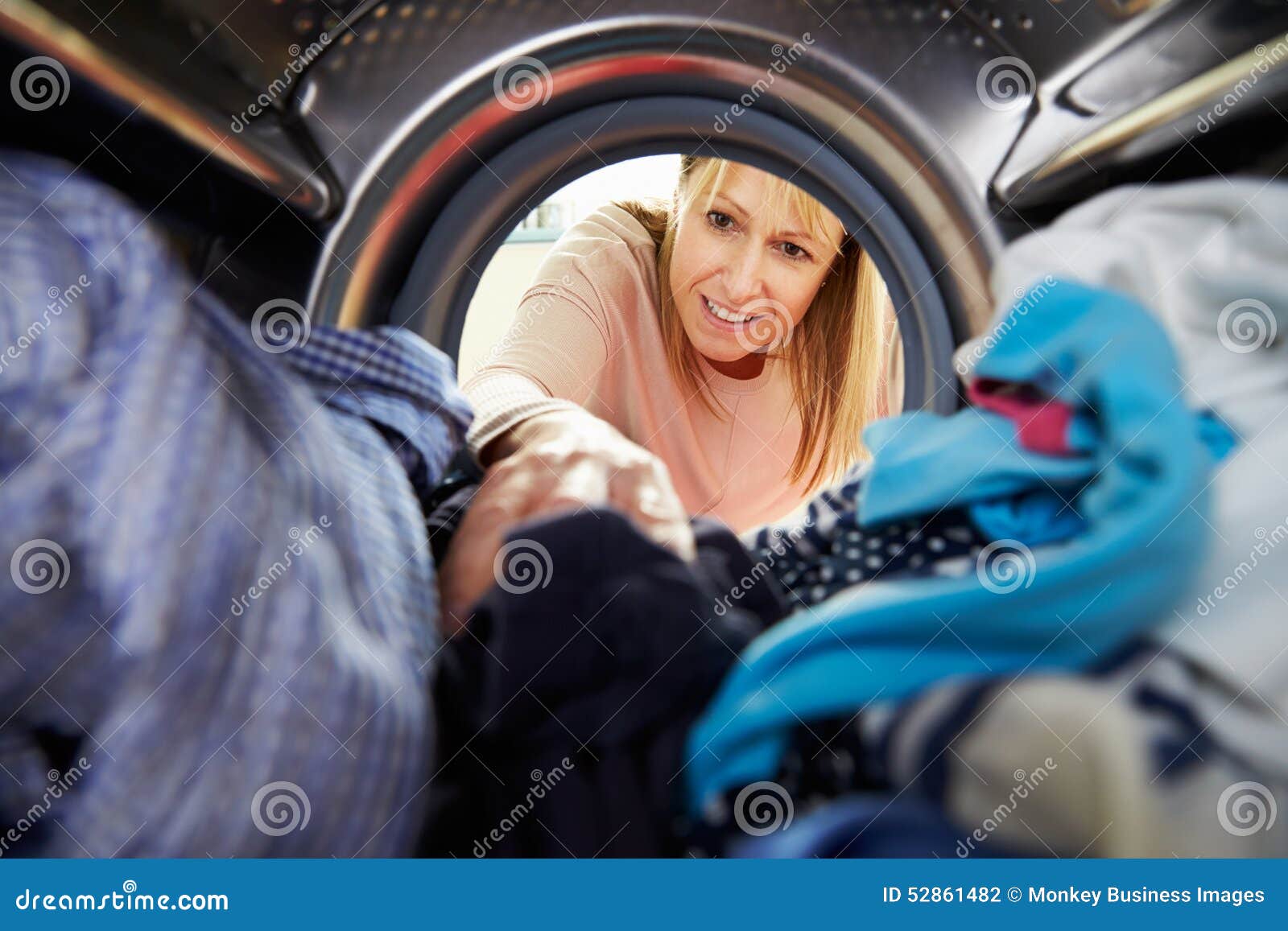 Woman Doing Laundry Reaching Inside Washing Machine Stock Photo - Image ...