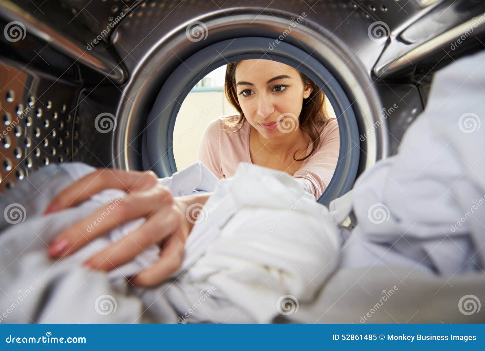 Woman Doing Laundry Reaching Inside Washing Machine Stock Image - Image ...