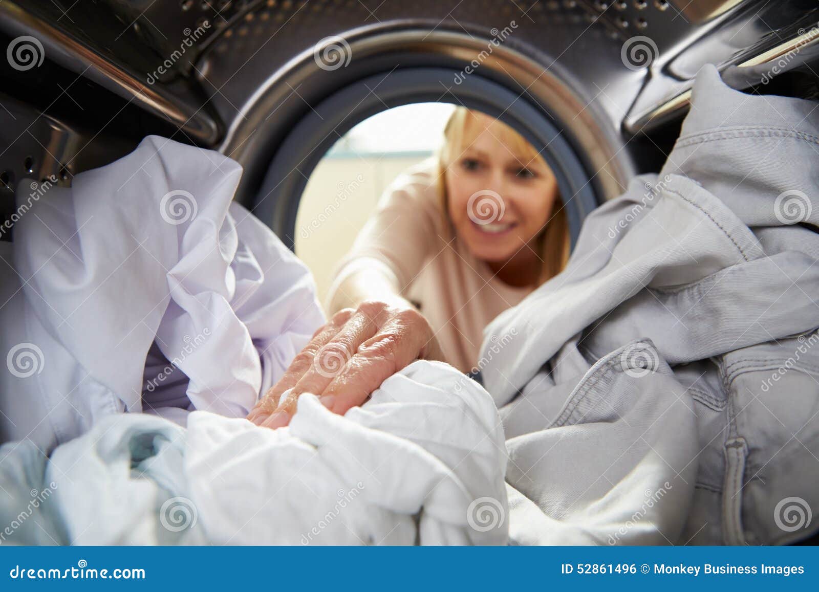 Woman Doing Laundry Reaching Inside Washing Machine Stock Photo - Image ...