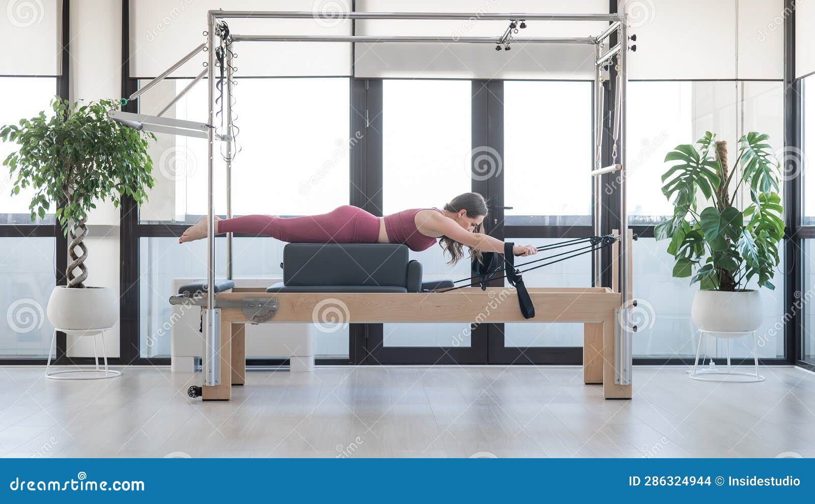 Woman Doing Pilates Exercise on Cadillac Reformer Machine. Stock Photo ...