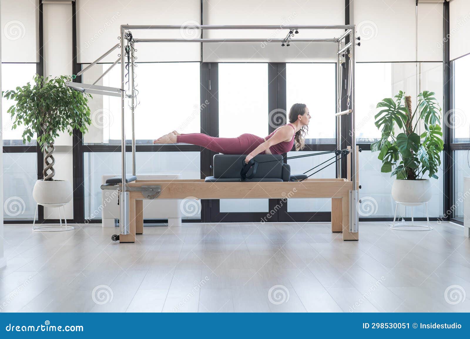 Woman Doing Pilates Exercise on Cadillac Reformer Machine. Stock Image ...