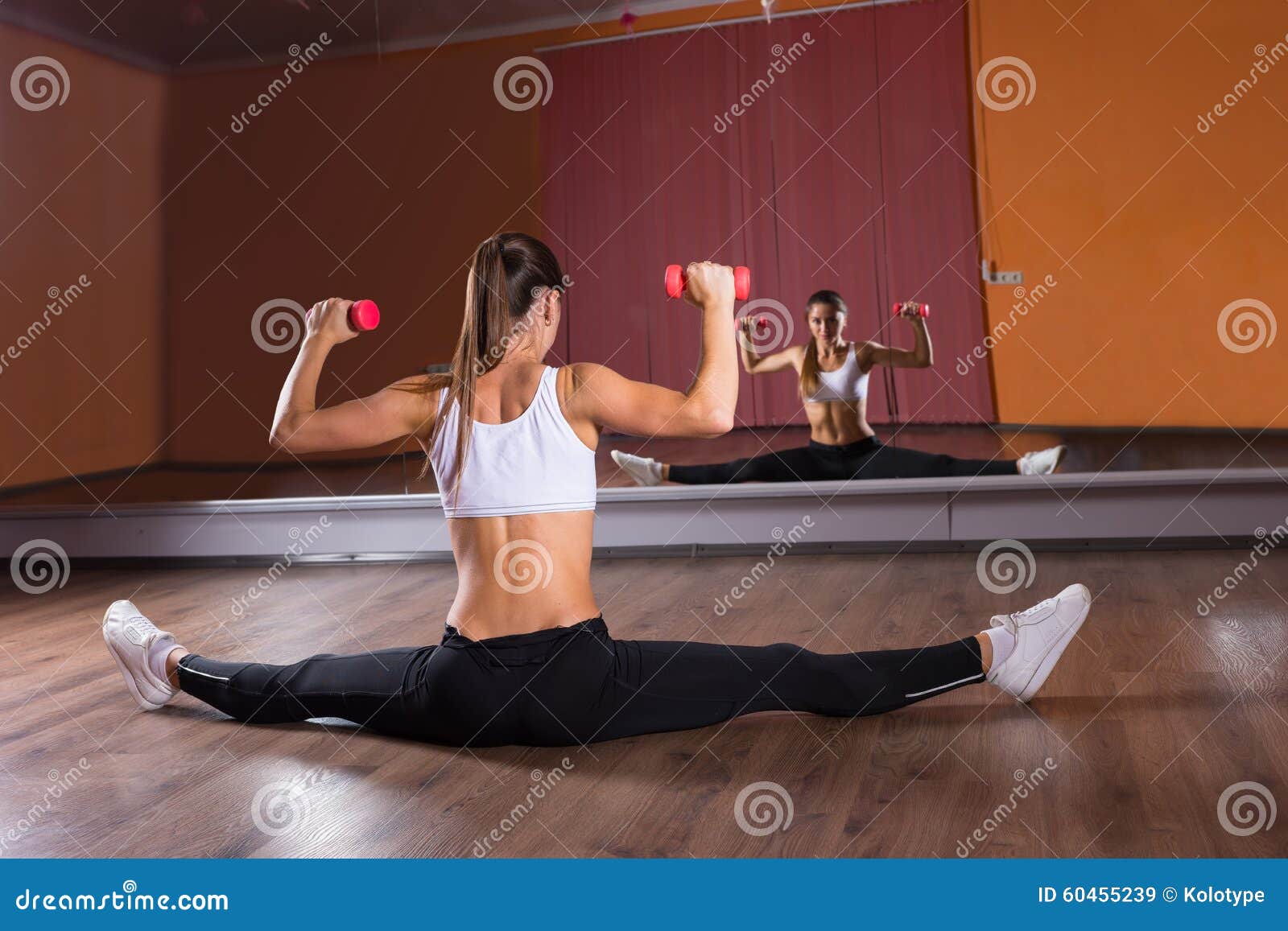 Woman Doing Splits and Lifting Weights in Studio Stock Image - Image of ...