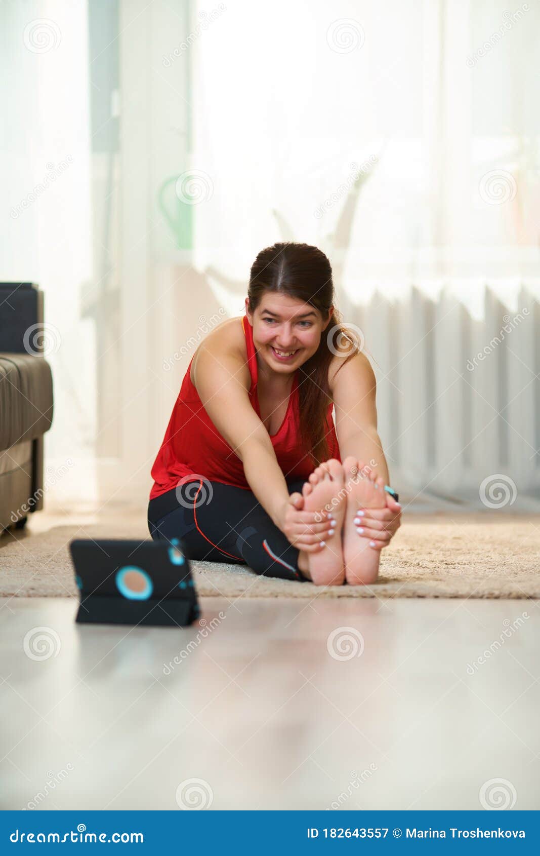 Woman is Doing Stretching, Practicing Yoga Exercises at Home Using ...