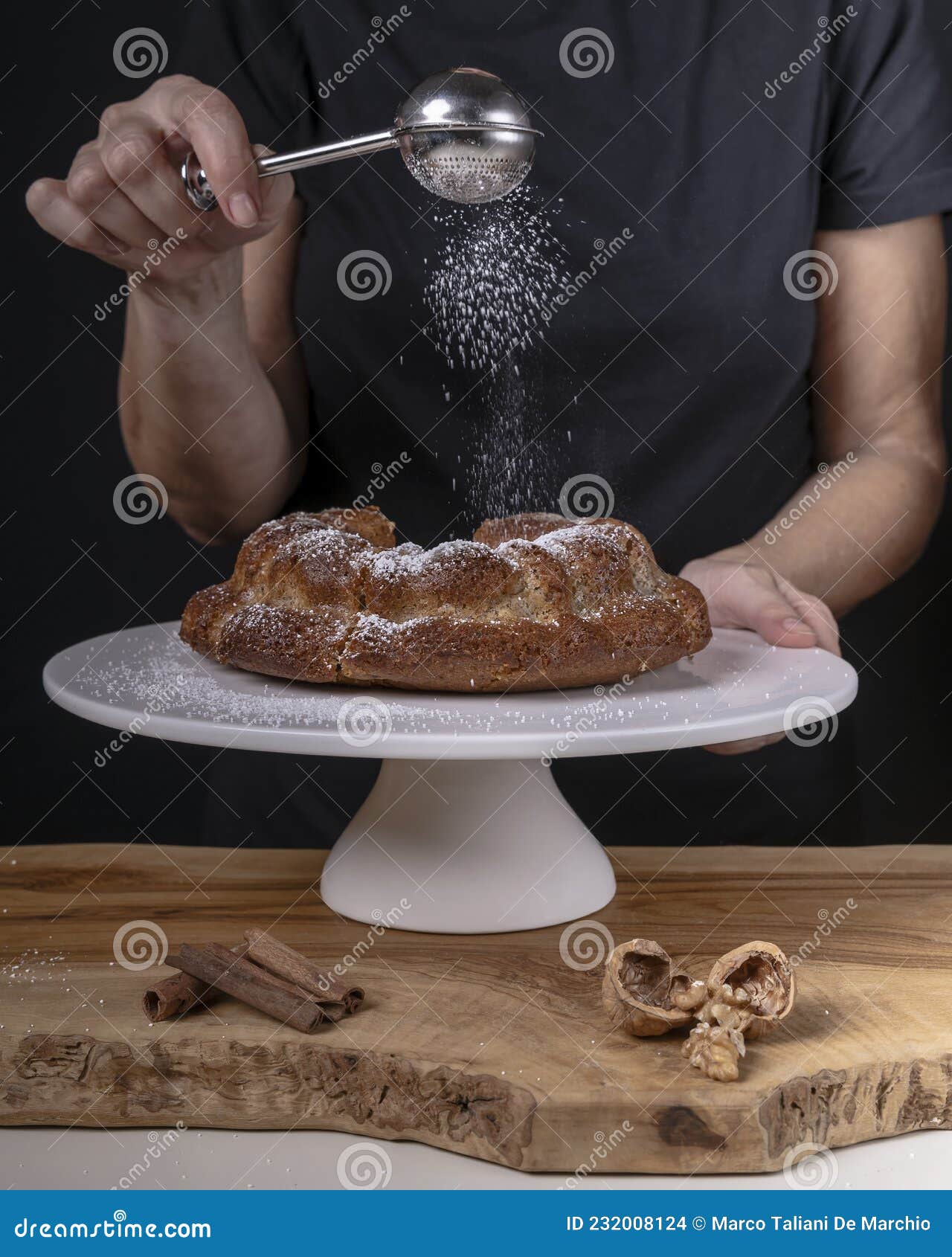 A Woman Drops Icing Sugar Onto a Donut Using a Duster Stock Photo ...