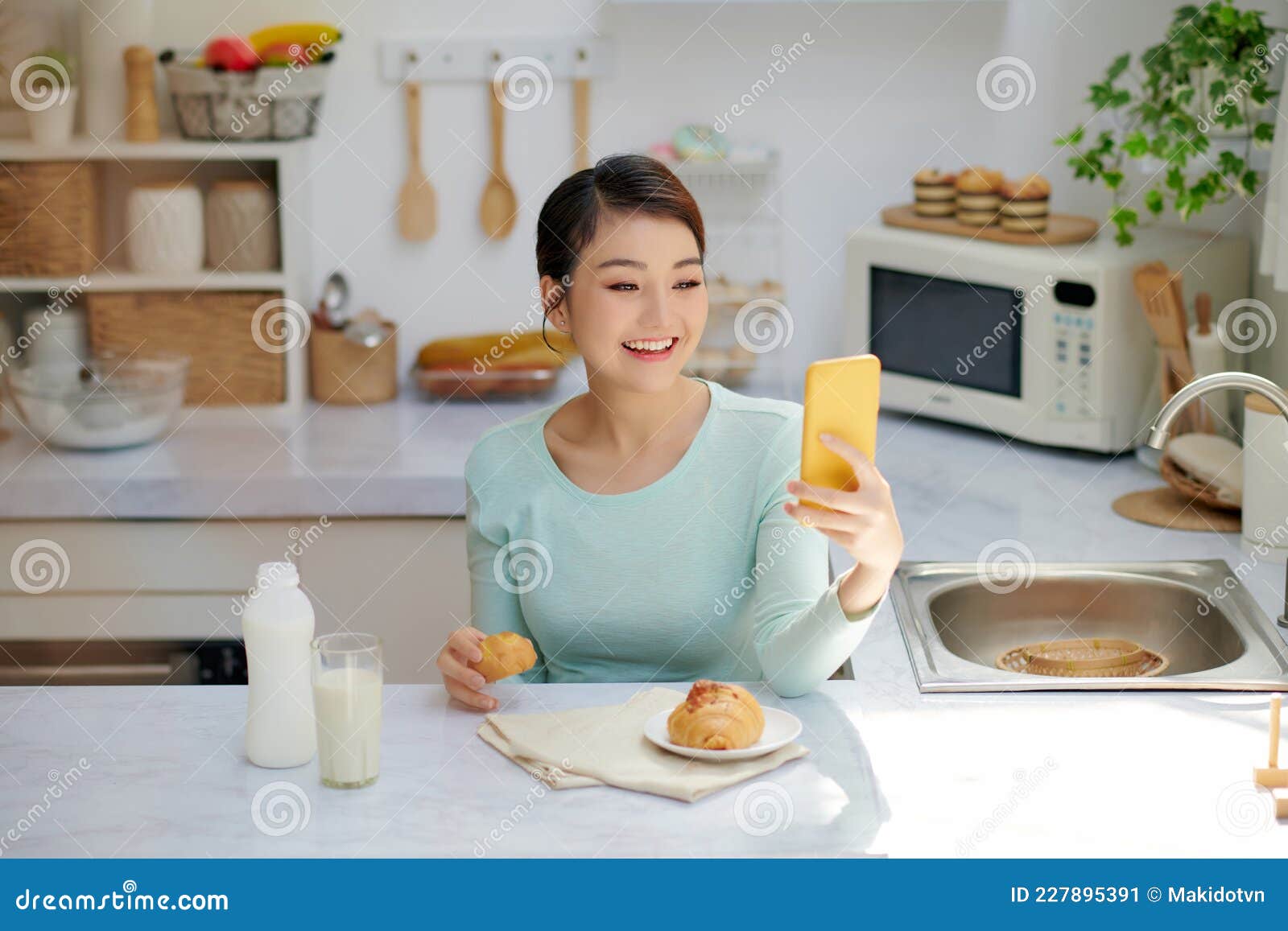 Woman Eating Breakfast Whilst Using Mobile Phone Stock Image - Image of ...