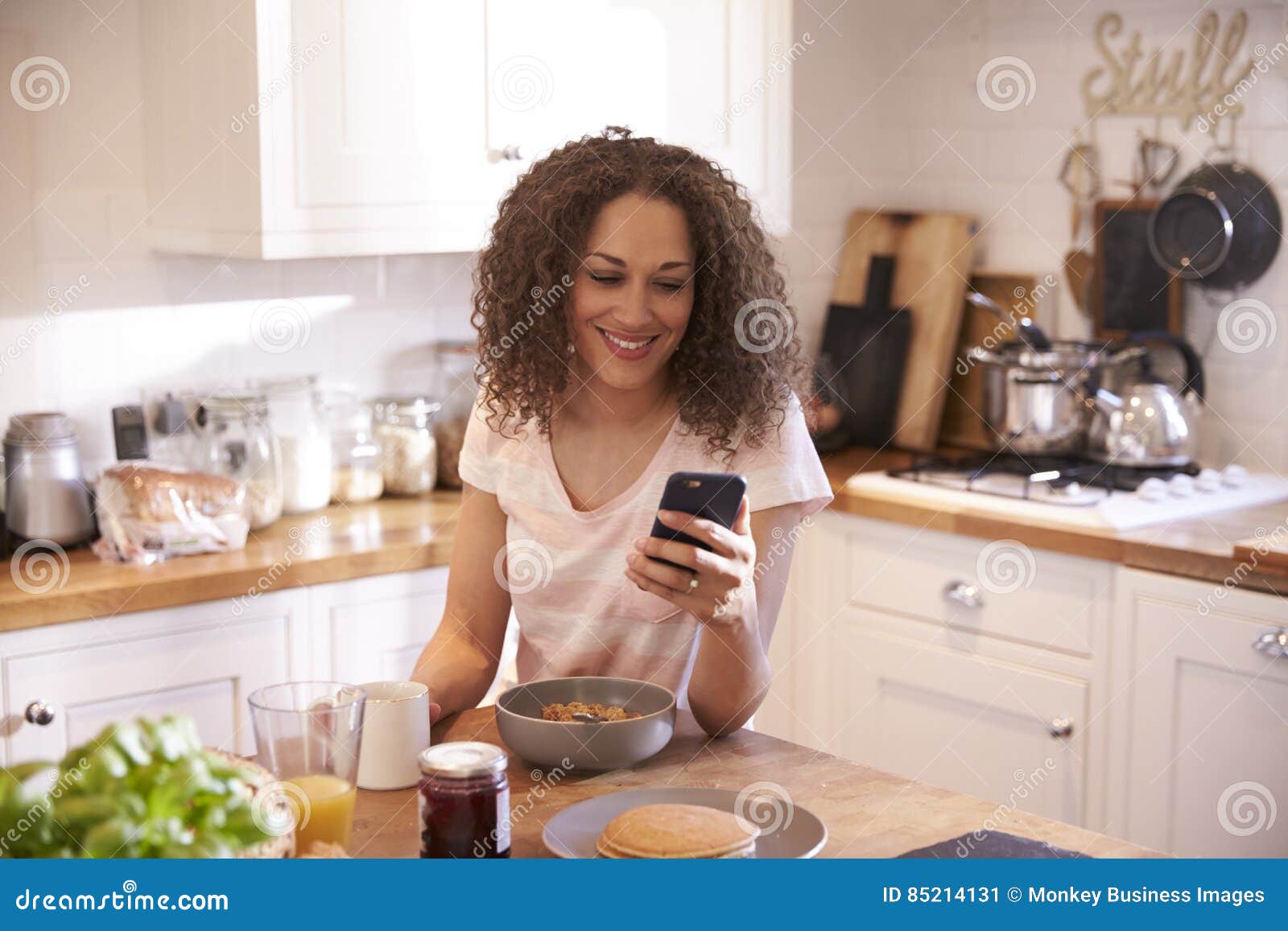 Woman Eating Breakfast Whilst Using Mobile Phone Stock Image - Image of ...