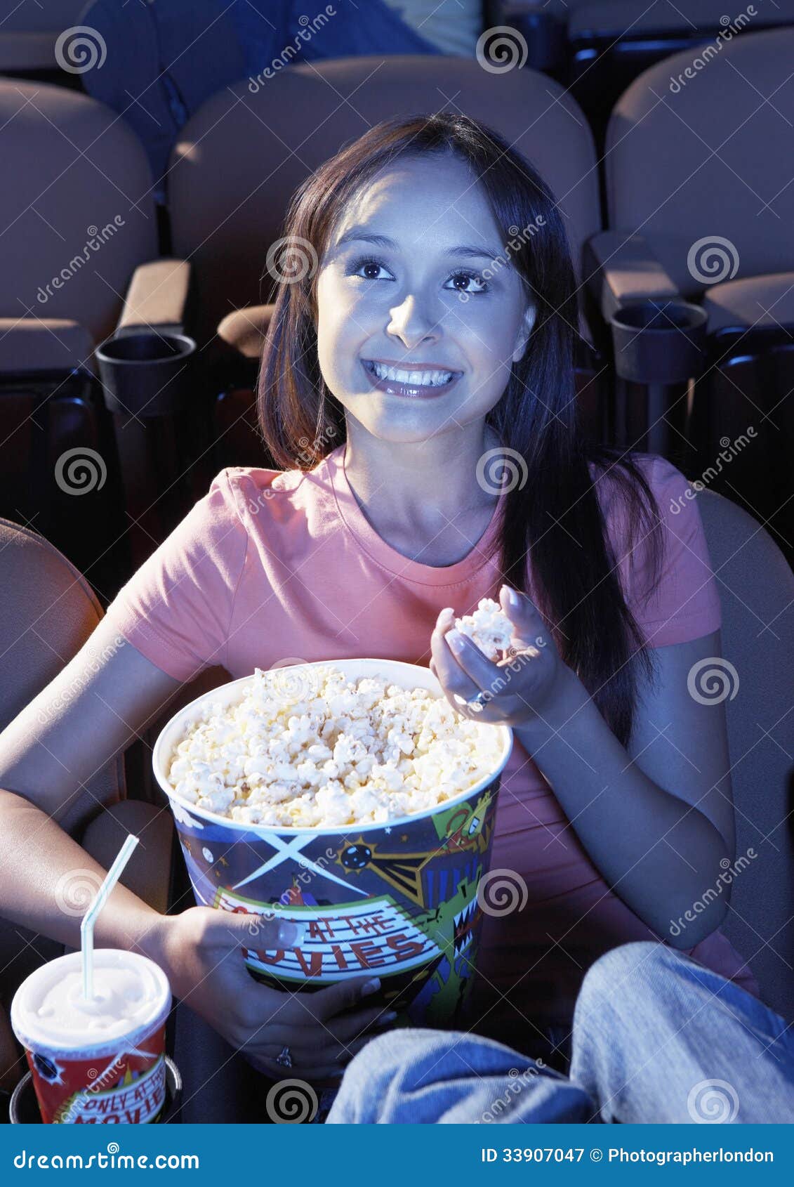 Woman Eating Popcorn While Watching Movie In Theater Stock Image