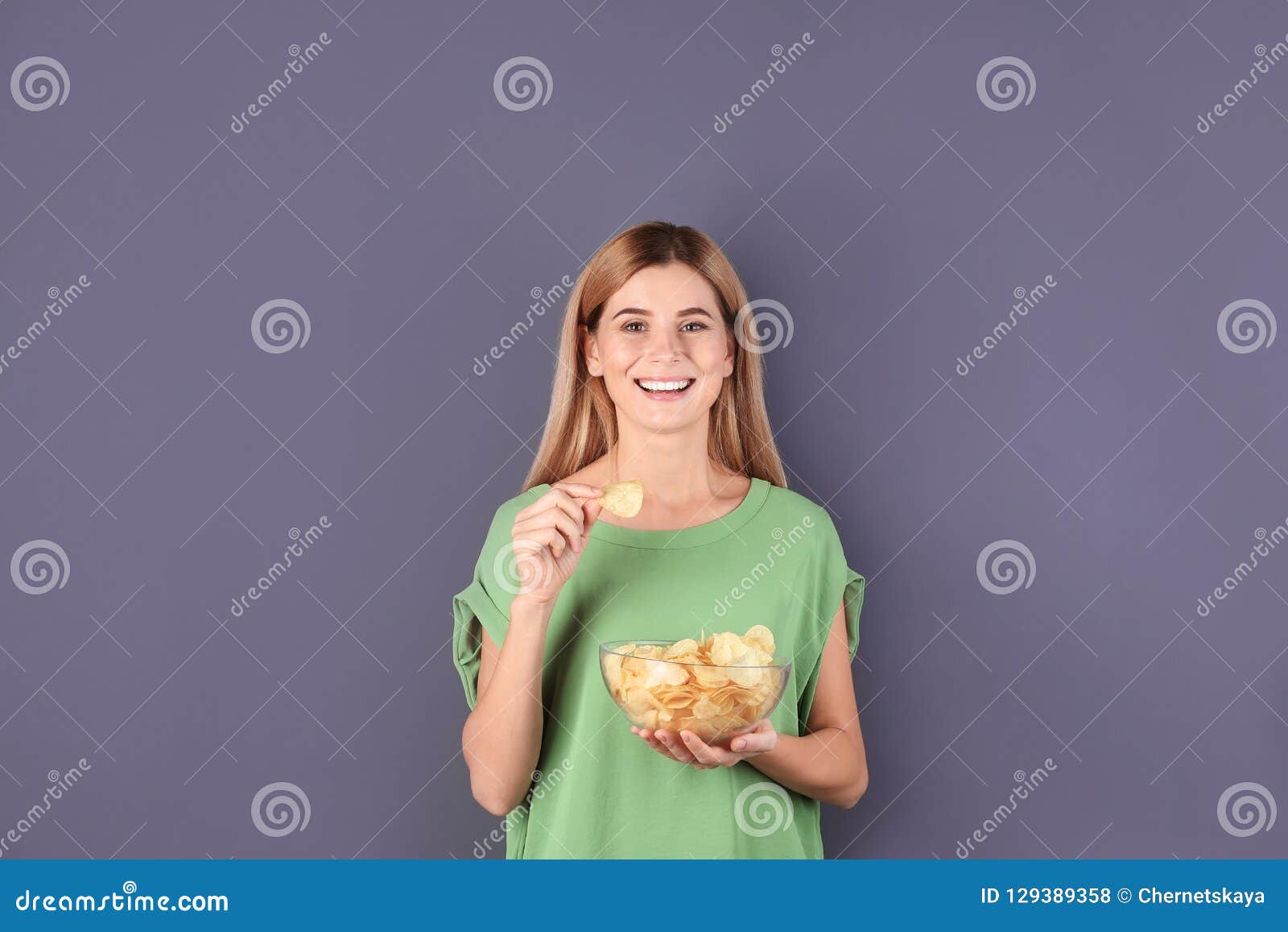 Woman eating potato chips stock photo. Image of adult - 129389358