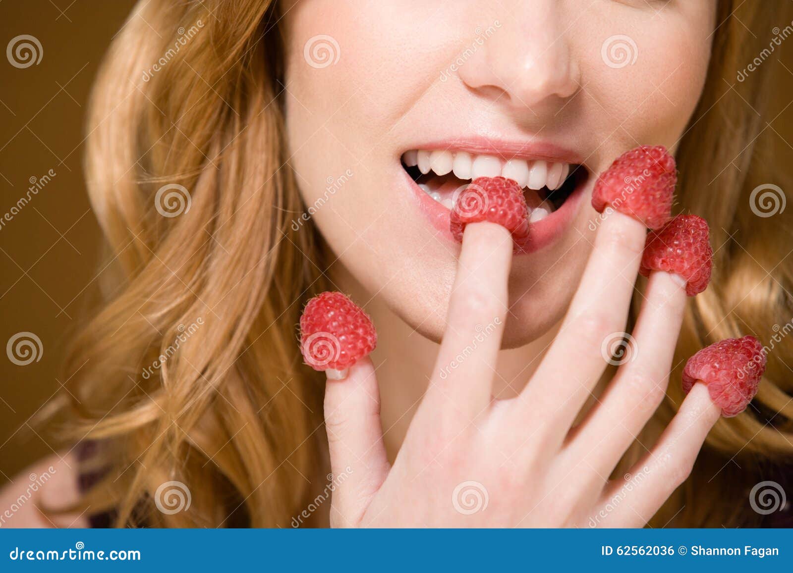 Woman eating raspberries stock photo. Image of holding - 62562036