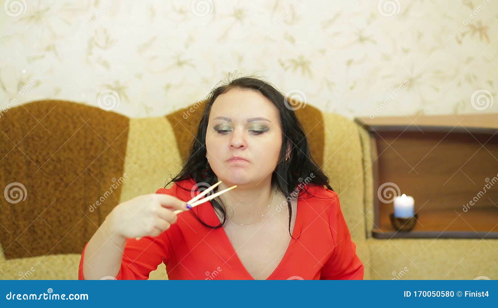 A Woman Eats Rolls with Chopsticks while Chewing Carefully Stock ...