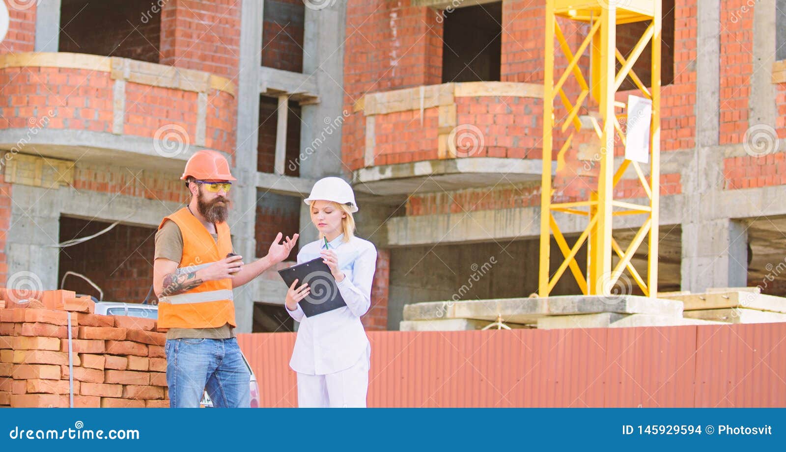 Woman Engineer and Builder Communicate at Construction Site ...