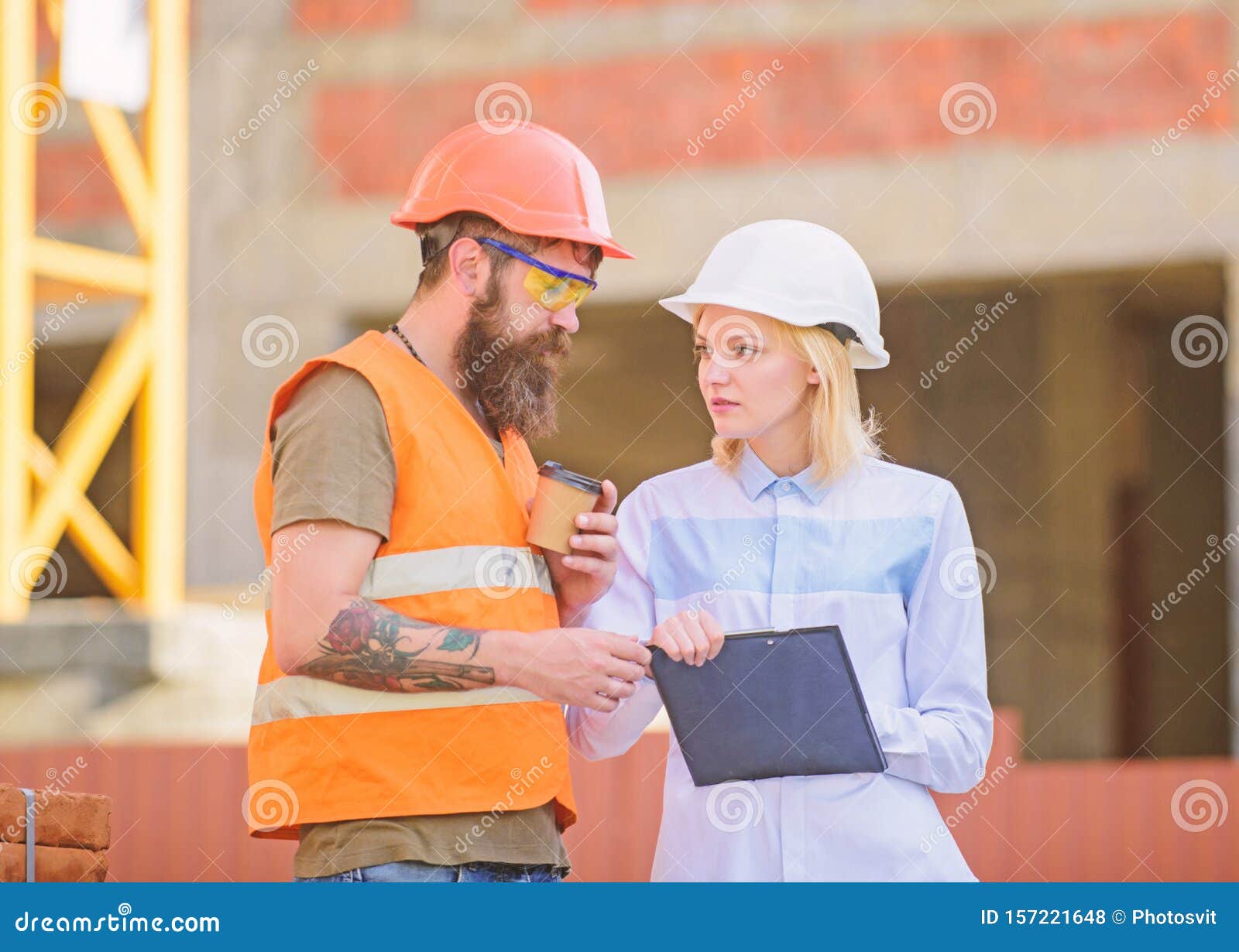 Woman Engineer and Builder Communicate Construction Site. Discuss ...