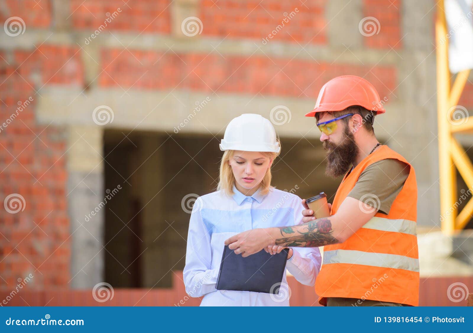 Woman Engineer and Builder Communicate Construction Site. Construction ...