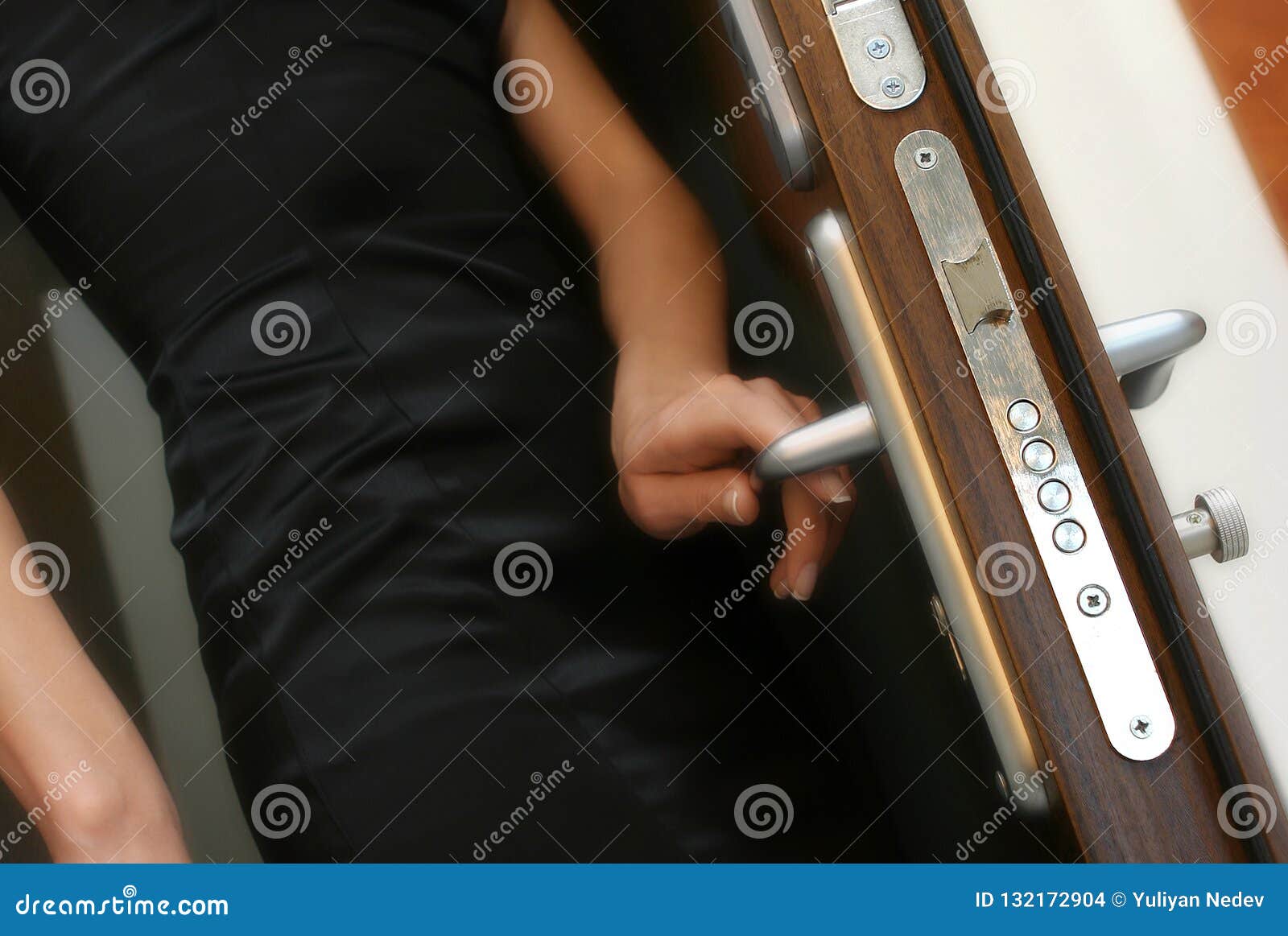 A Woman Entering a Room Holding a Door Handle Stock Photo - Image of ...